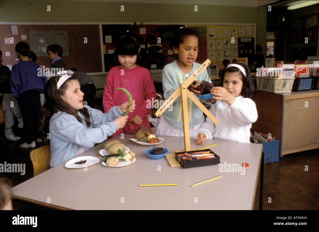 A group of primary school children weighing objects on balance Stock ...