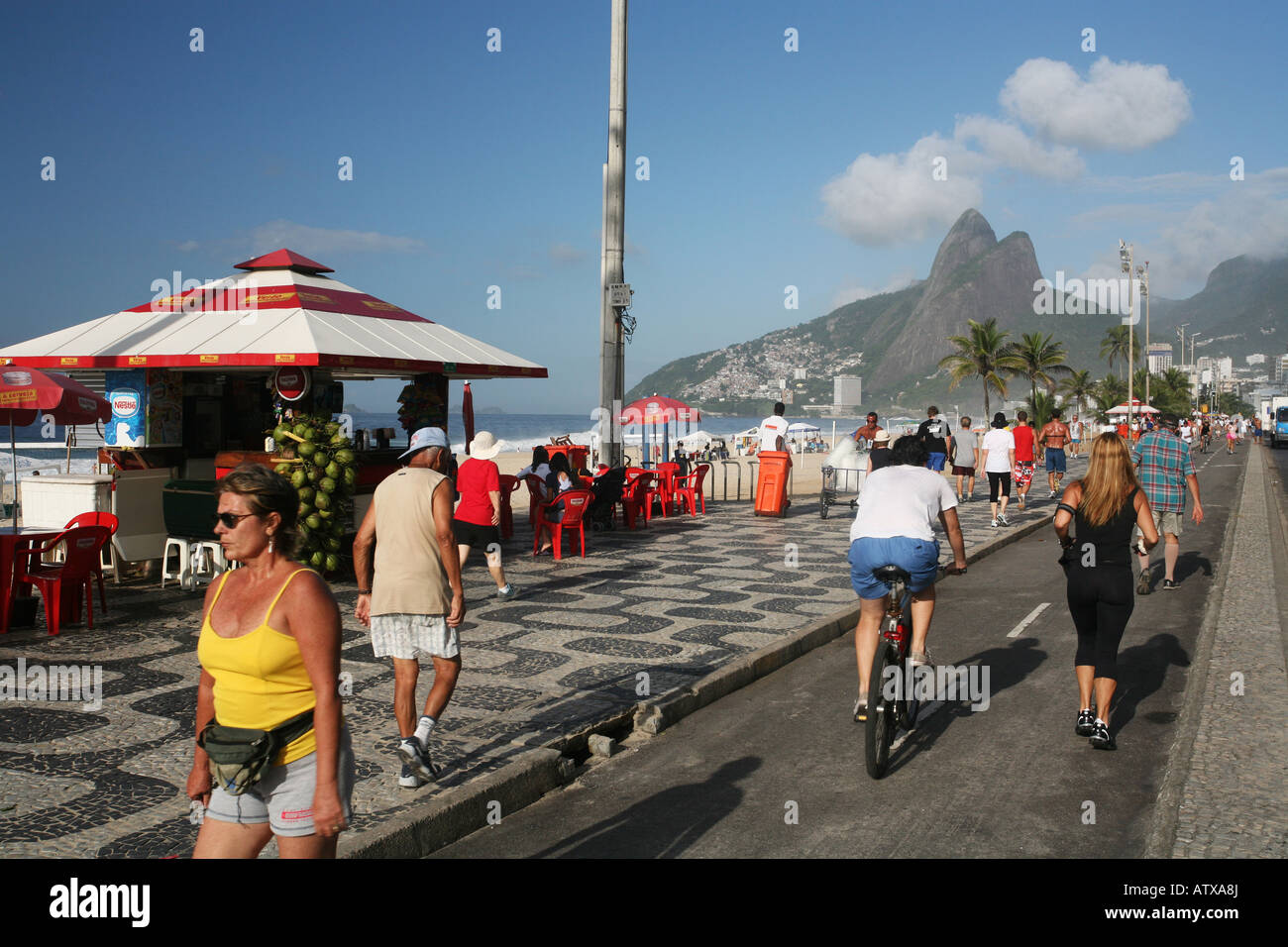 Ipanema promenade sea front with tourists strolling, cyclist and runner ...