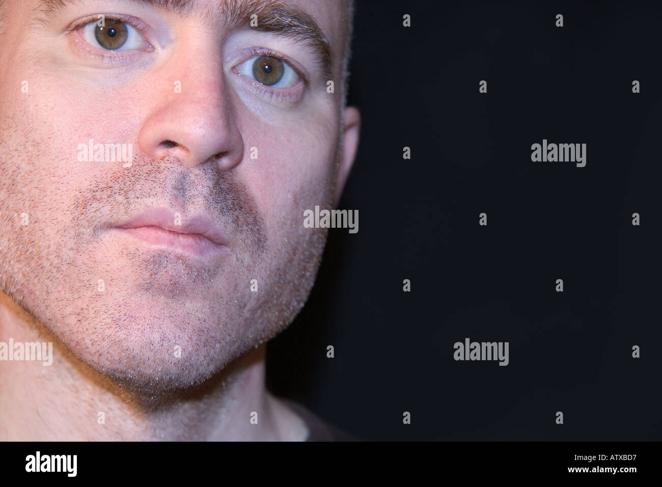Unshaven man staring with black background model released Stock Photo ...