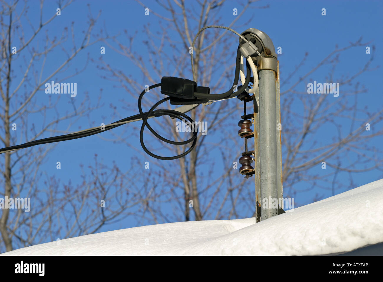 electricity mast by snowy roof Stock Photo - Alamy
