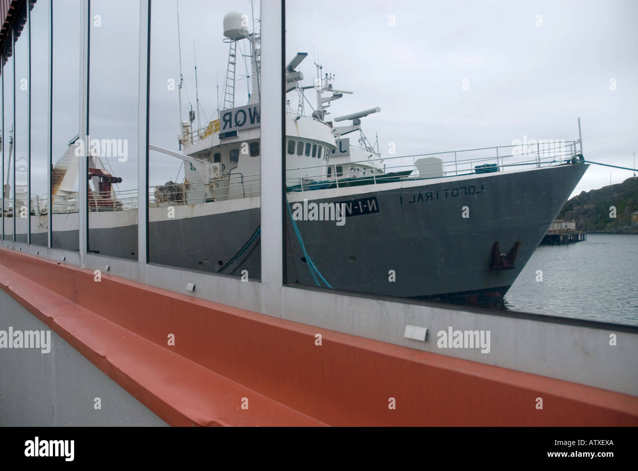 Reflection of commercial cod fishing trawler in factory window ...