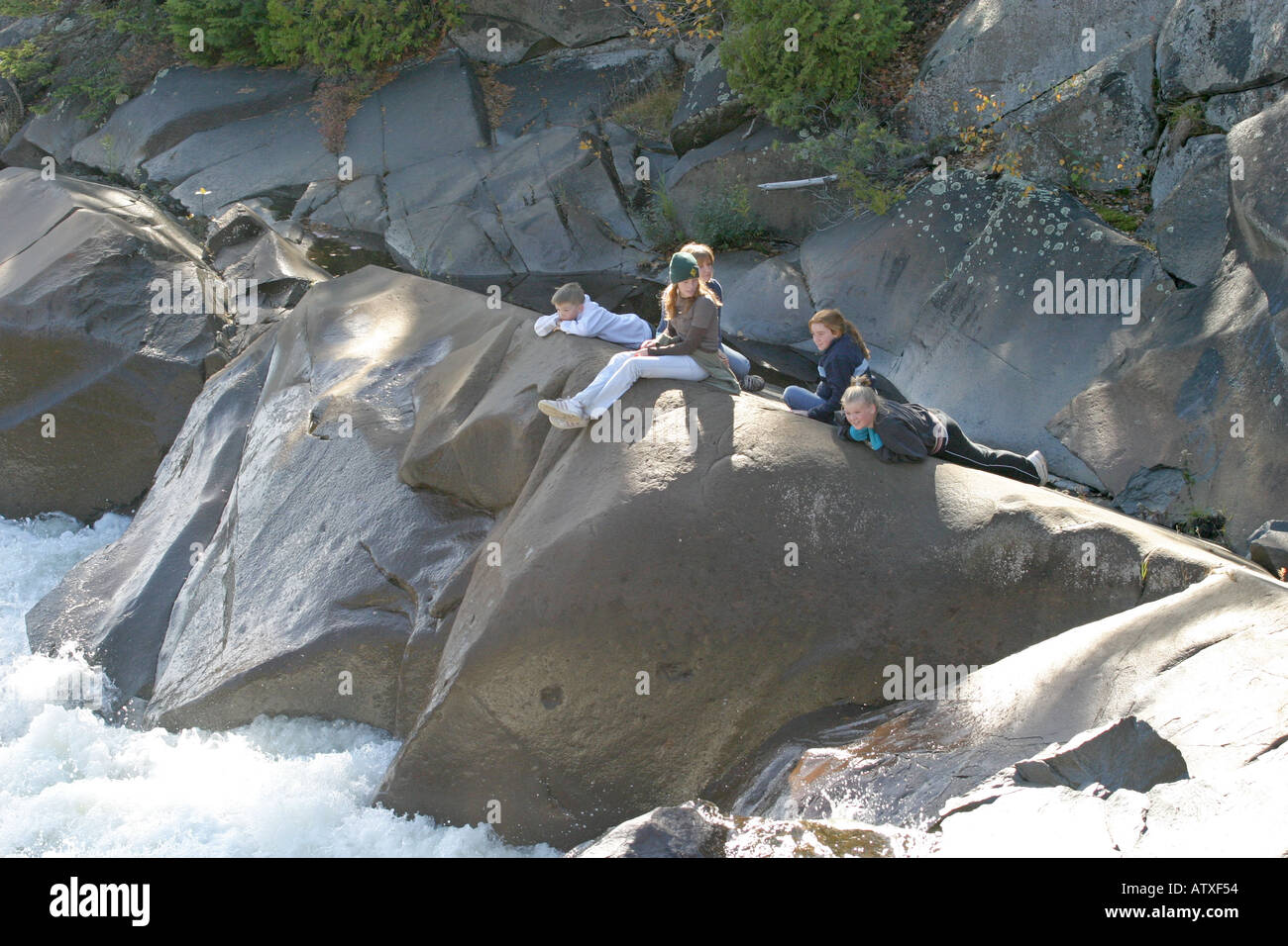 Children sitting on rock hi-res stock photography and images - Alamy