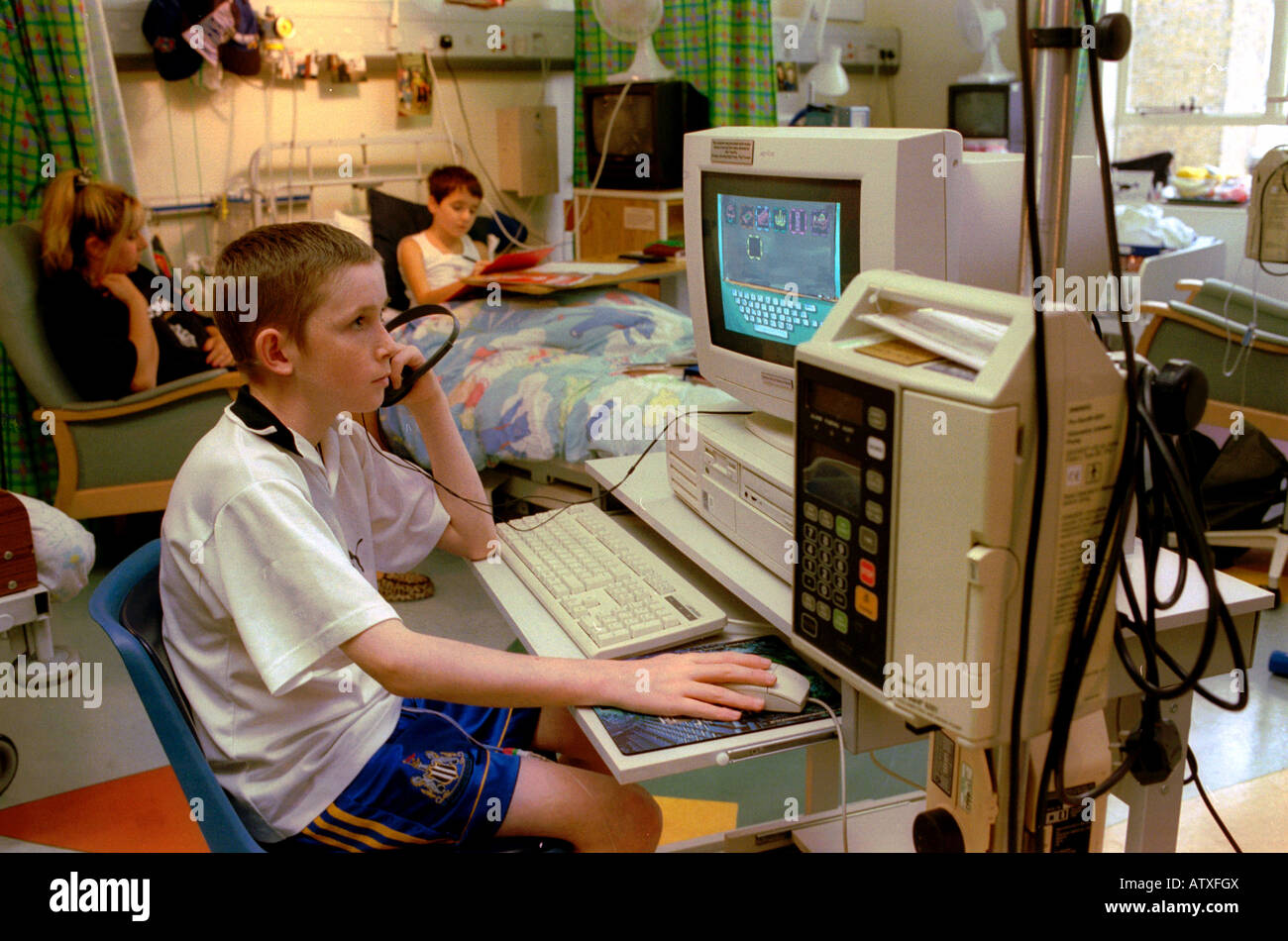 Young boy doing homework on computer in children's ward of Whitechapel ...