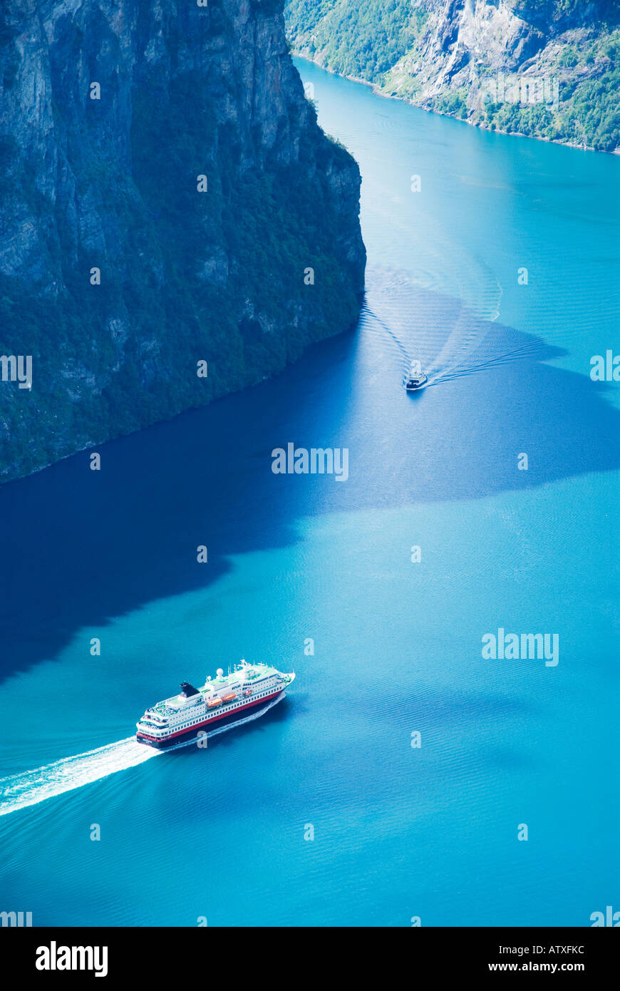 Hurtigruten coastal ferry travels around curve in Geirangerfjord ...