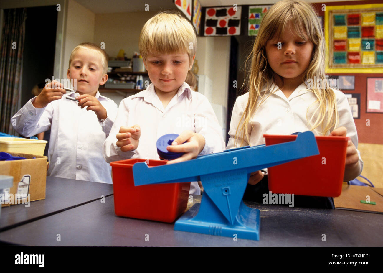 Group of primary children weighing objects during a maths class Stock ...