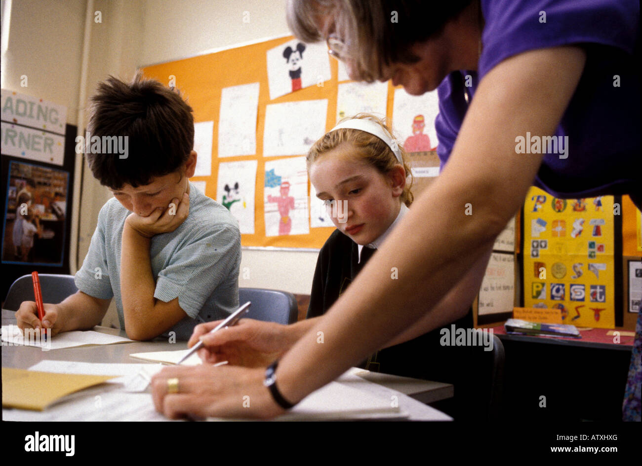 A primary school teacher correcting the work of the pupils Stock Photo ...