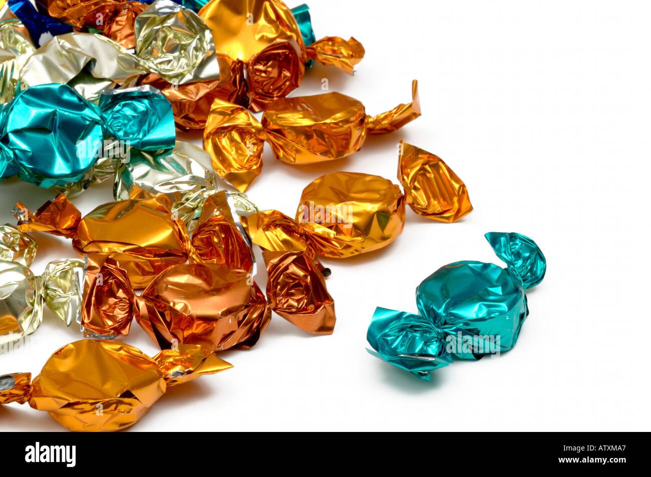 Colourful shiny paper wrapped toffee sweets on white background Stock ...