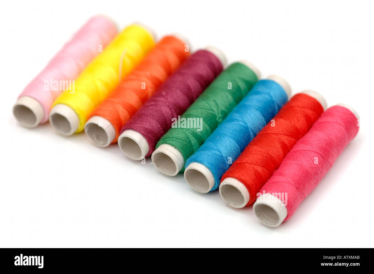 Array formed by Reels of colourful stitching threads on white ...