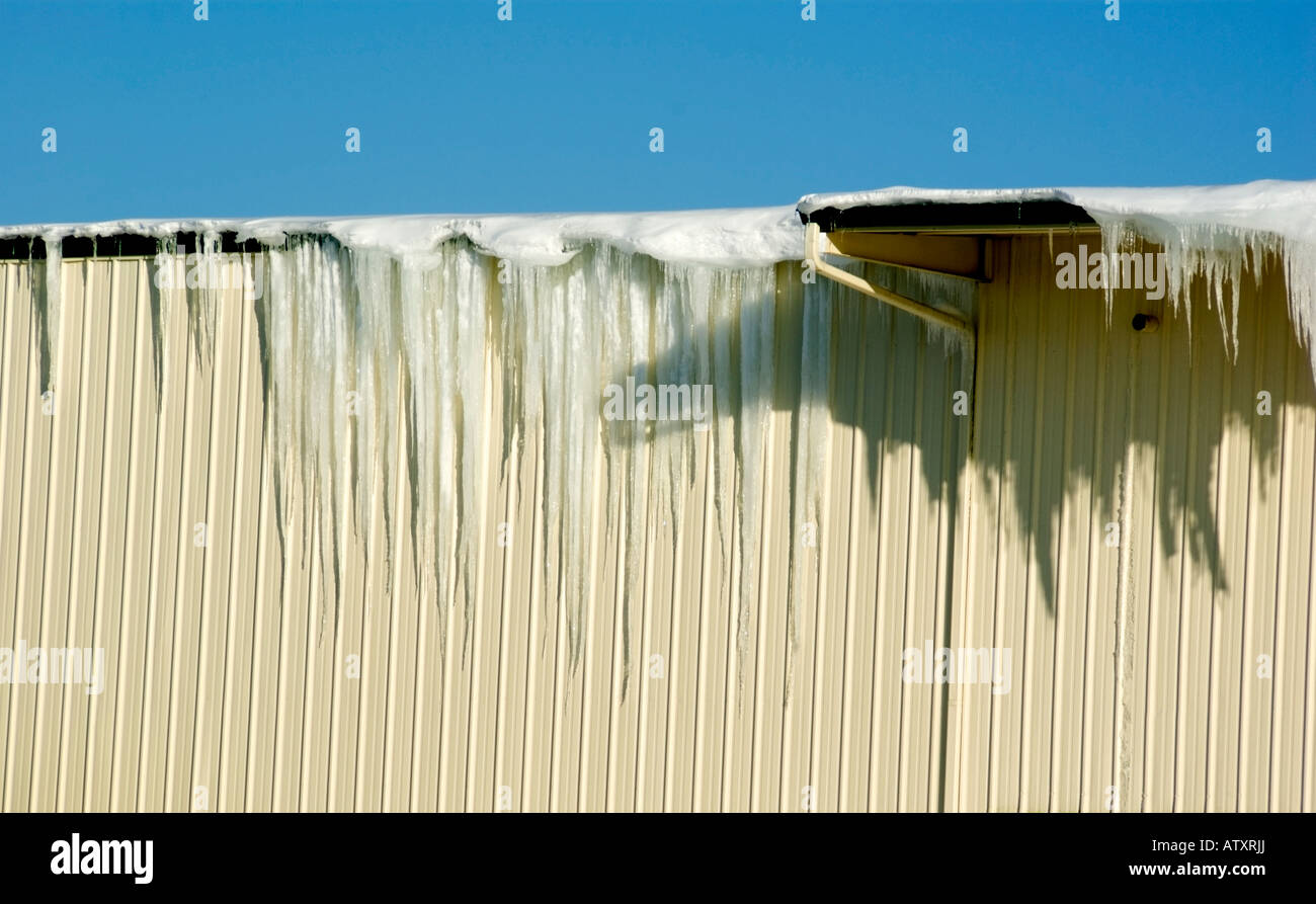Icicles on eaves of metal building Stock Photo - Alamy