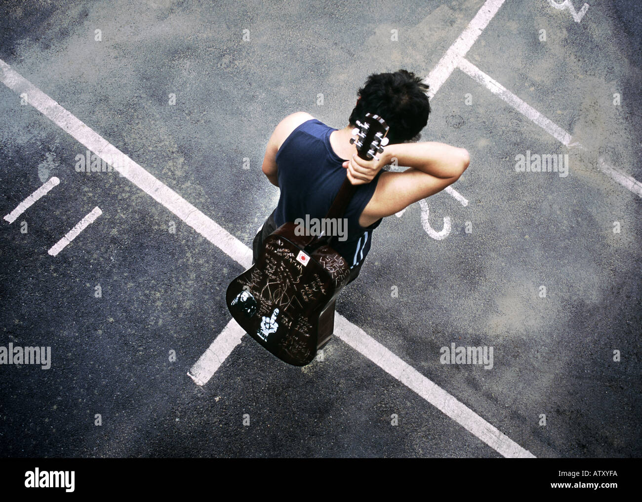 High angle of man holding guitar over back Stock Photo - Alamy