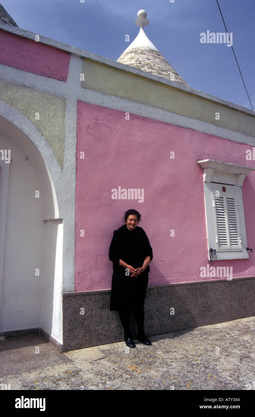 Southern Italian old woman outside pink trullo in Puglia, Italy Stock ...