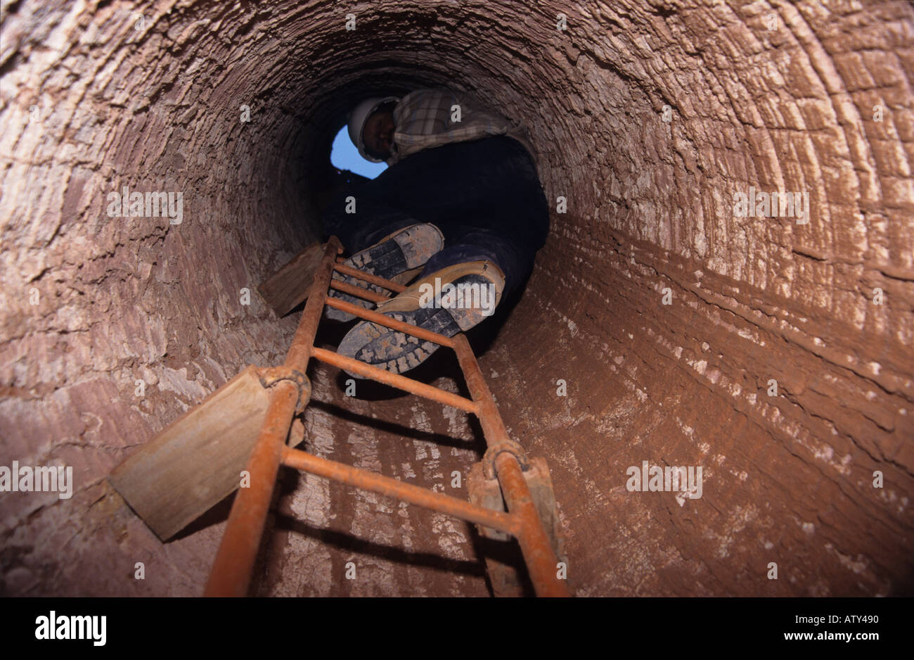 South Australia opal mineshaft from below seen as miner descends ladder ...
