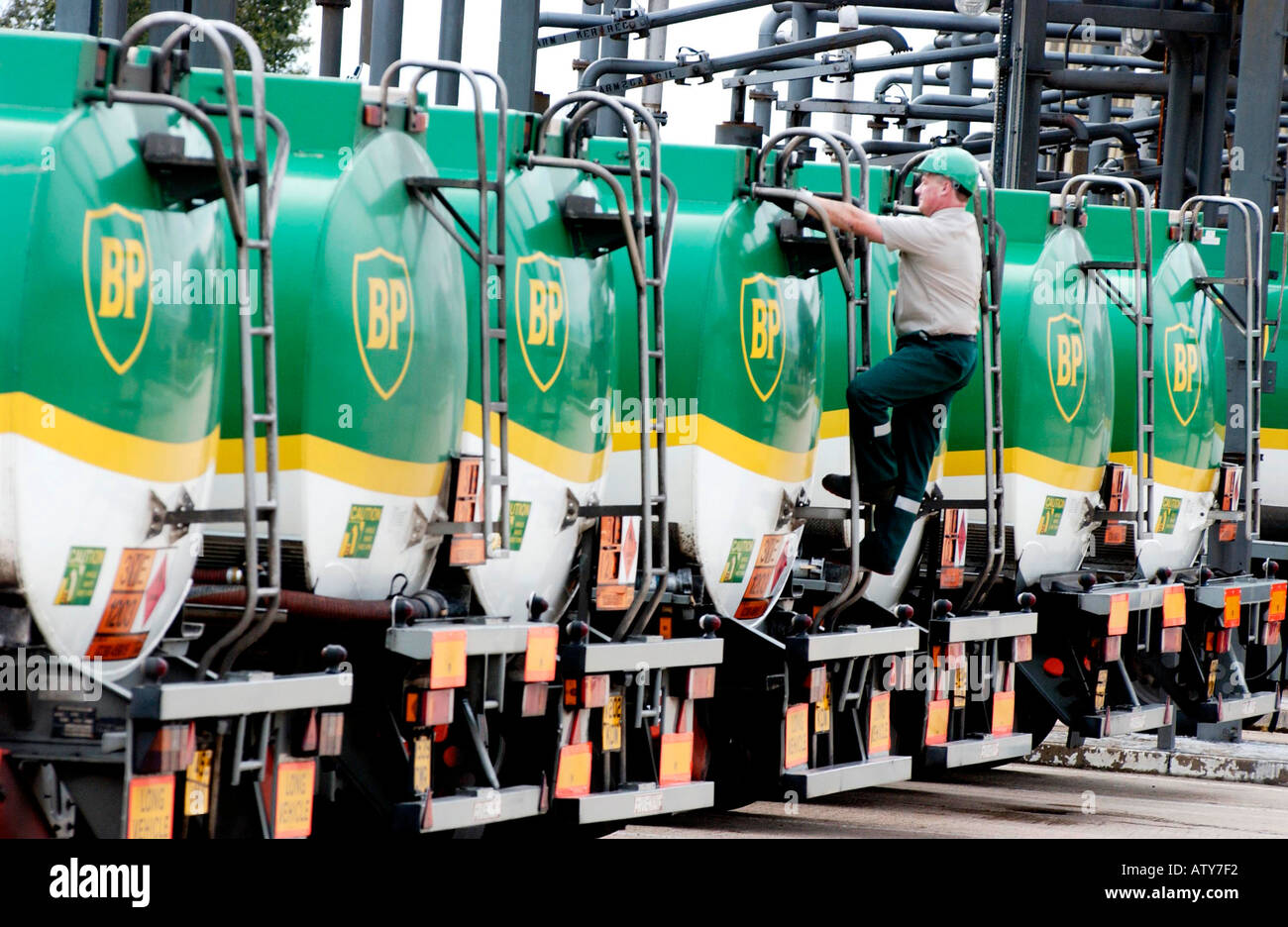 BP tankers lined up at an oil terminal with male worker in hard hat on ...