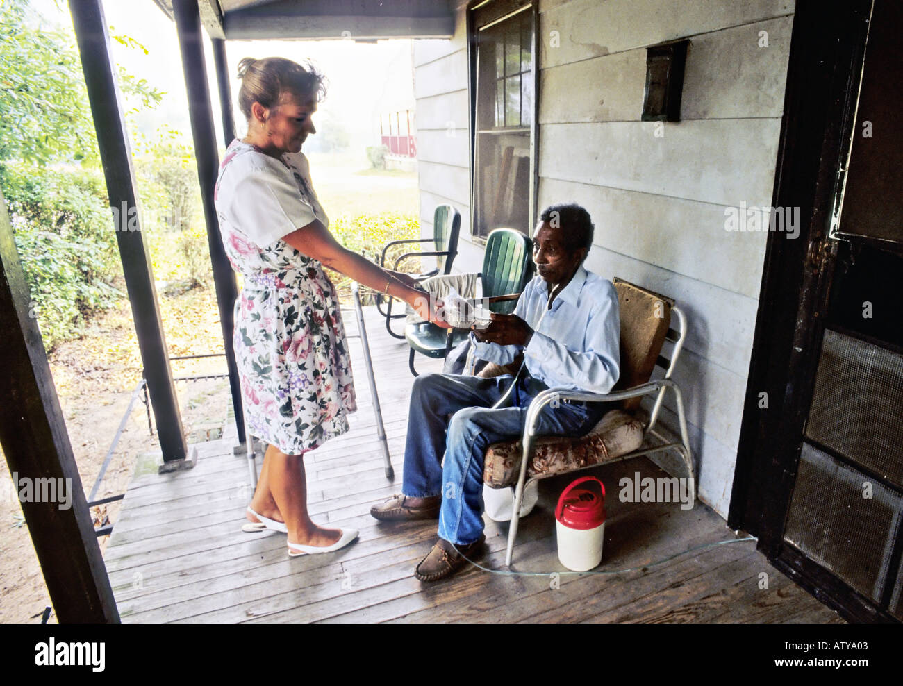 Meals on Wheels volunteer delivers meal to elderly handicapped African ...