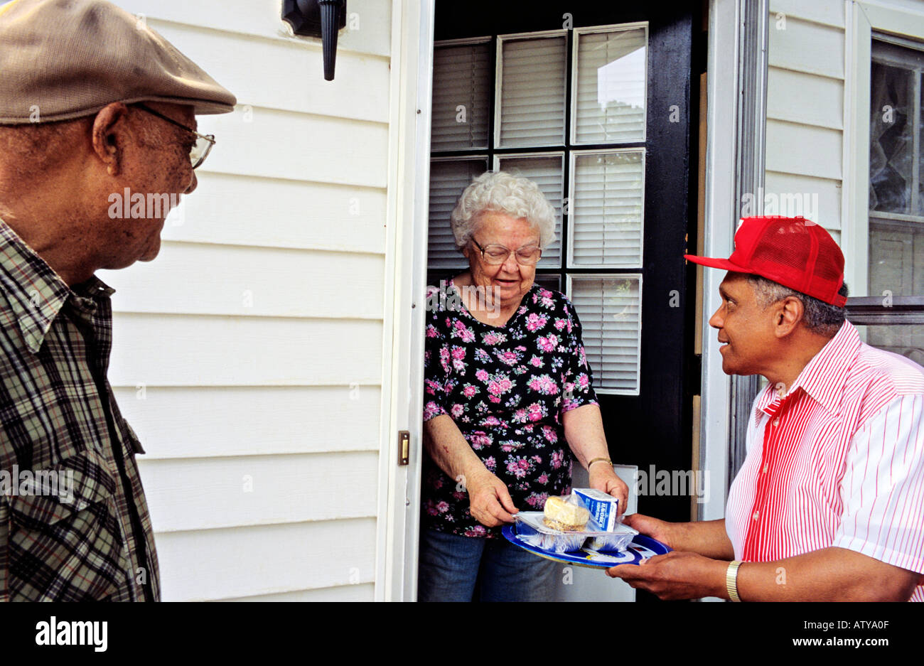Meals on Wheels volunteers deliver meal to elderly shut in Stock Photo ...