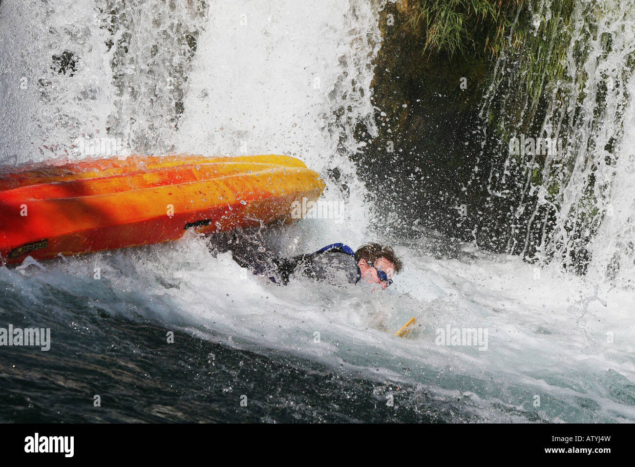 Man falling out of canoe in white water having gone over steep ...