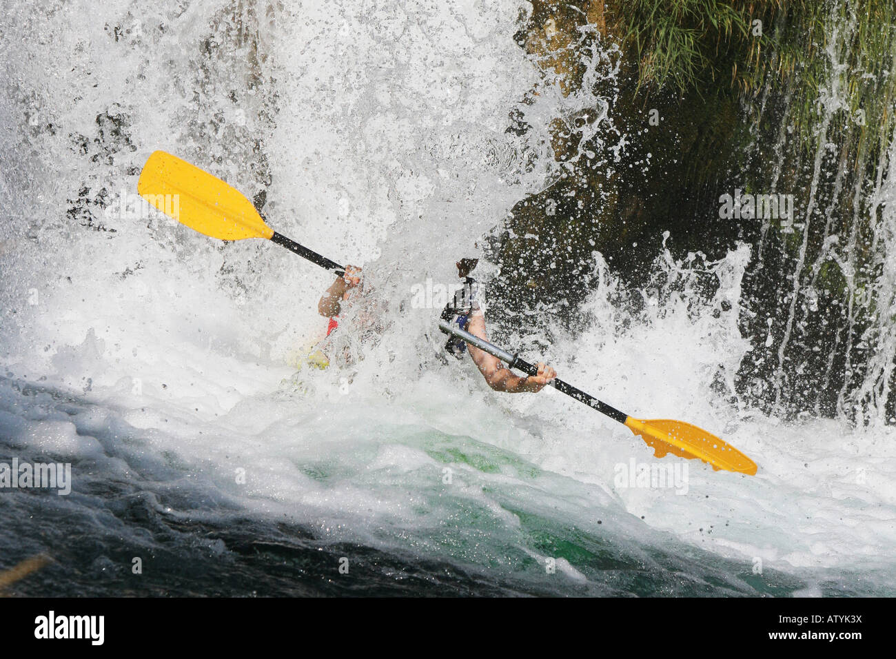 Tourist hidden by water splashing over canoe having gone over steep ...