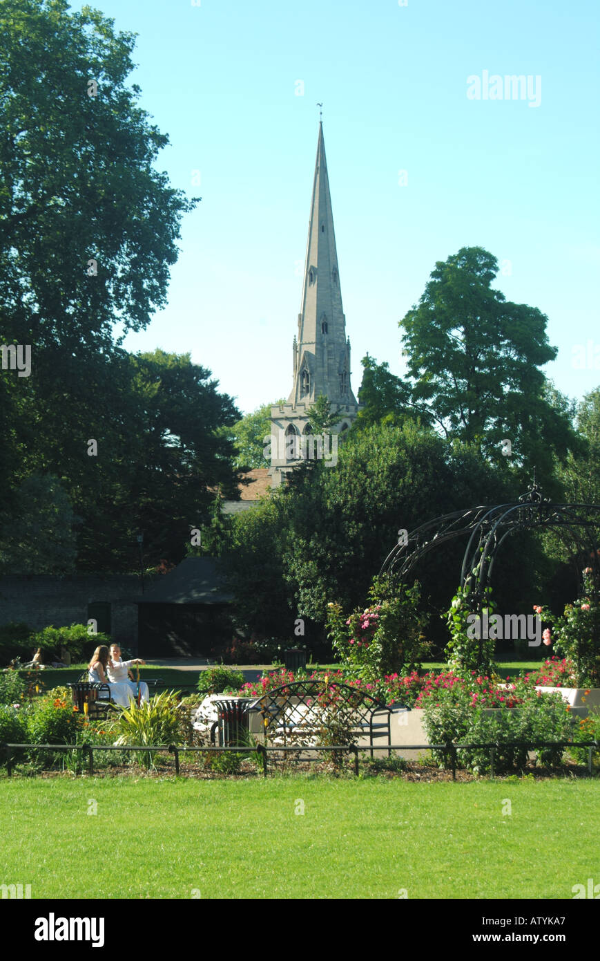Cambridge university town people sitting in open space park with church ...