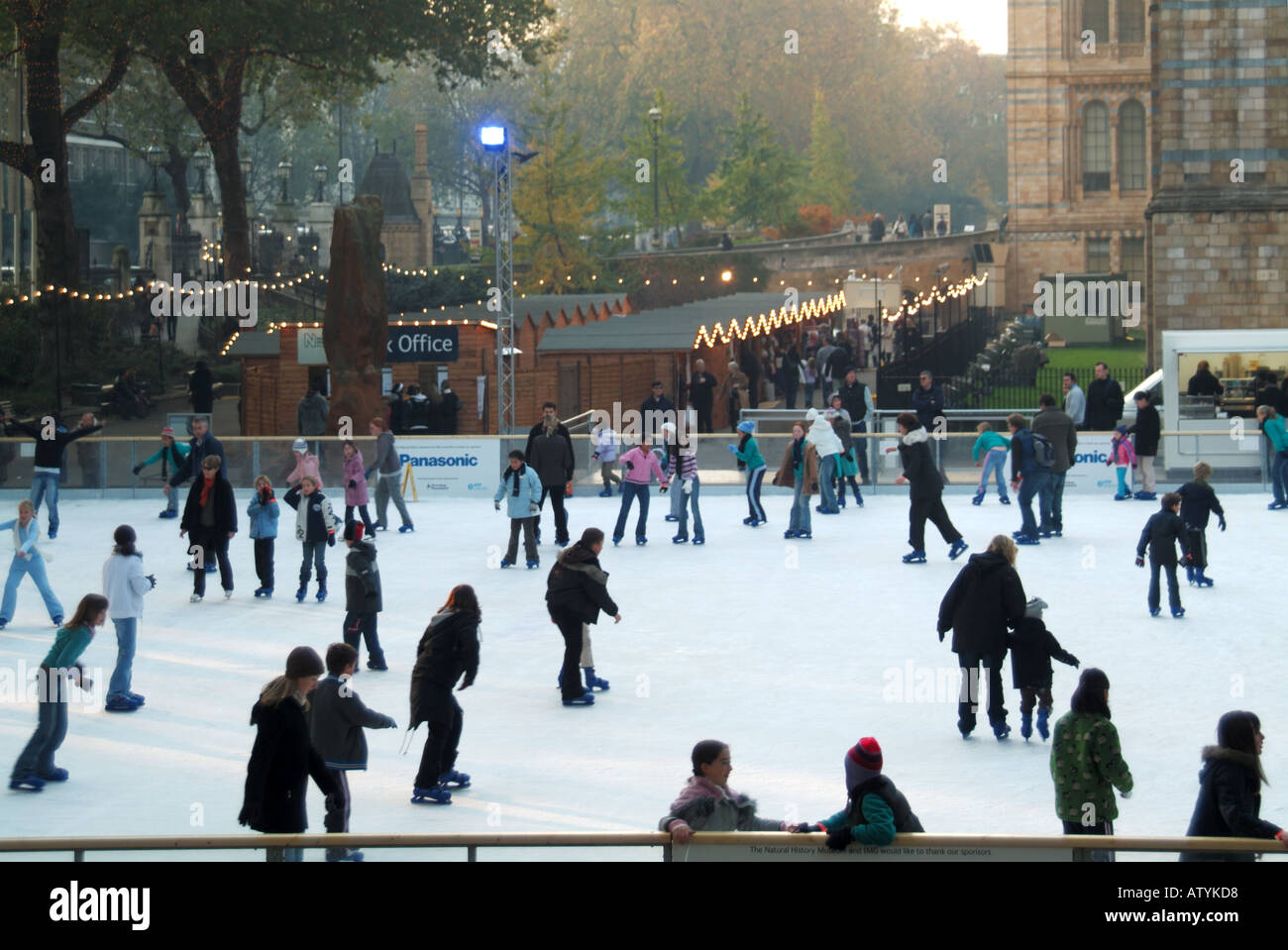 Adults & children on ice skates at temporary Christmas ice skating rink ...