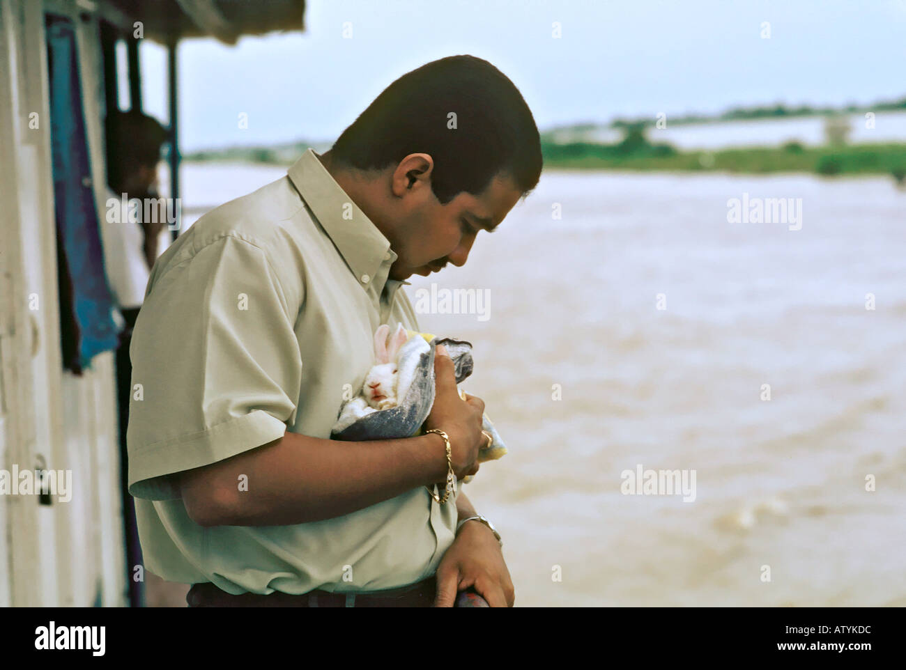 Passenger holding a rabbit on a ferry on the Magdalena River Colombia ...