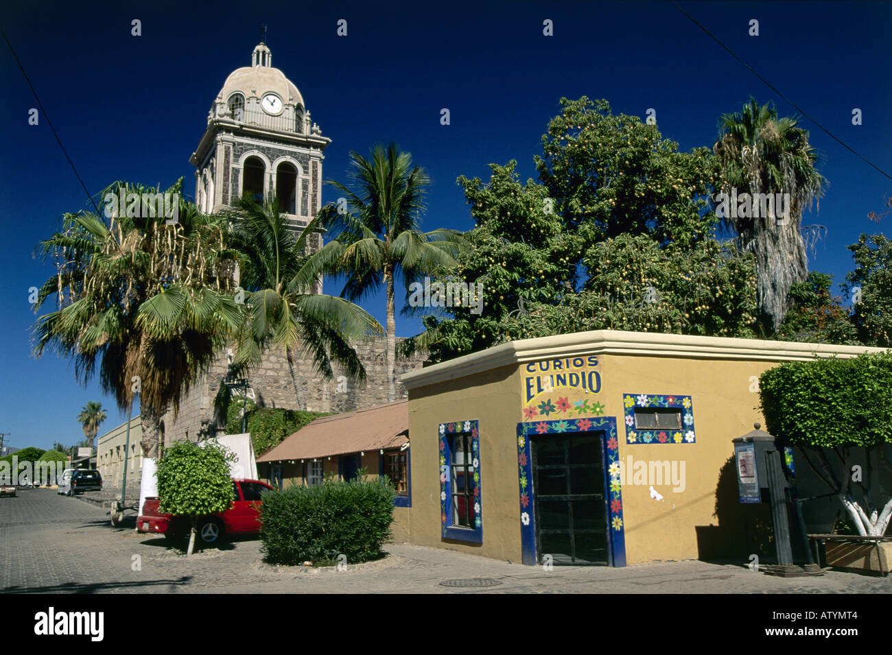 Clock tower of Our Lady of Loreto Church surrounded by palm trees at ...