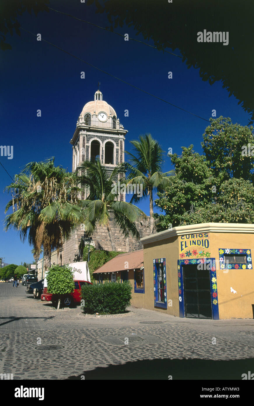 Clock tower of Our Lady of Loreto Church surrounded by palm trees at ...