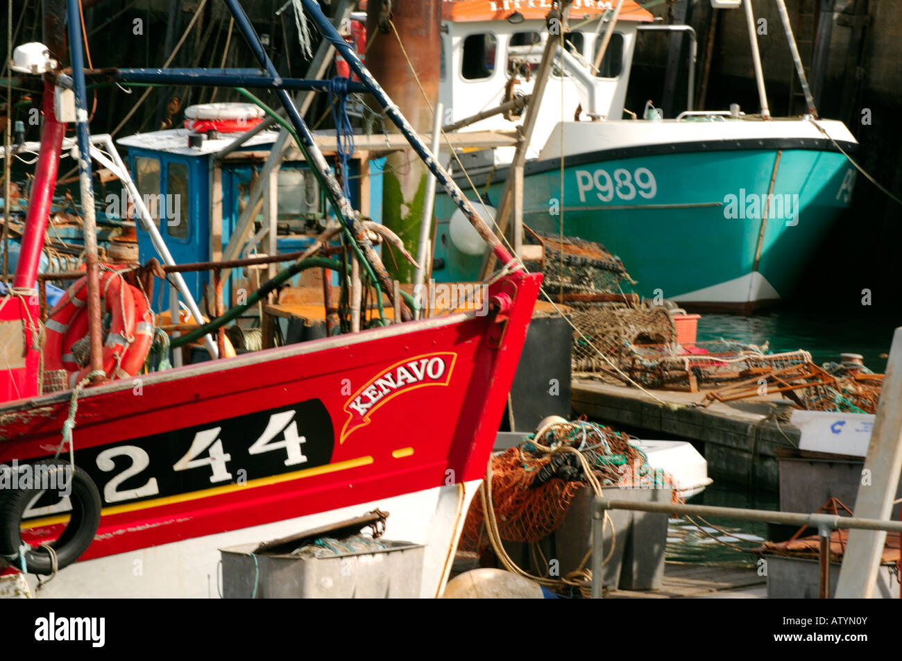 a harbour full of traditional fishing trawlers boats in brightly ...