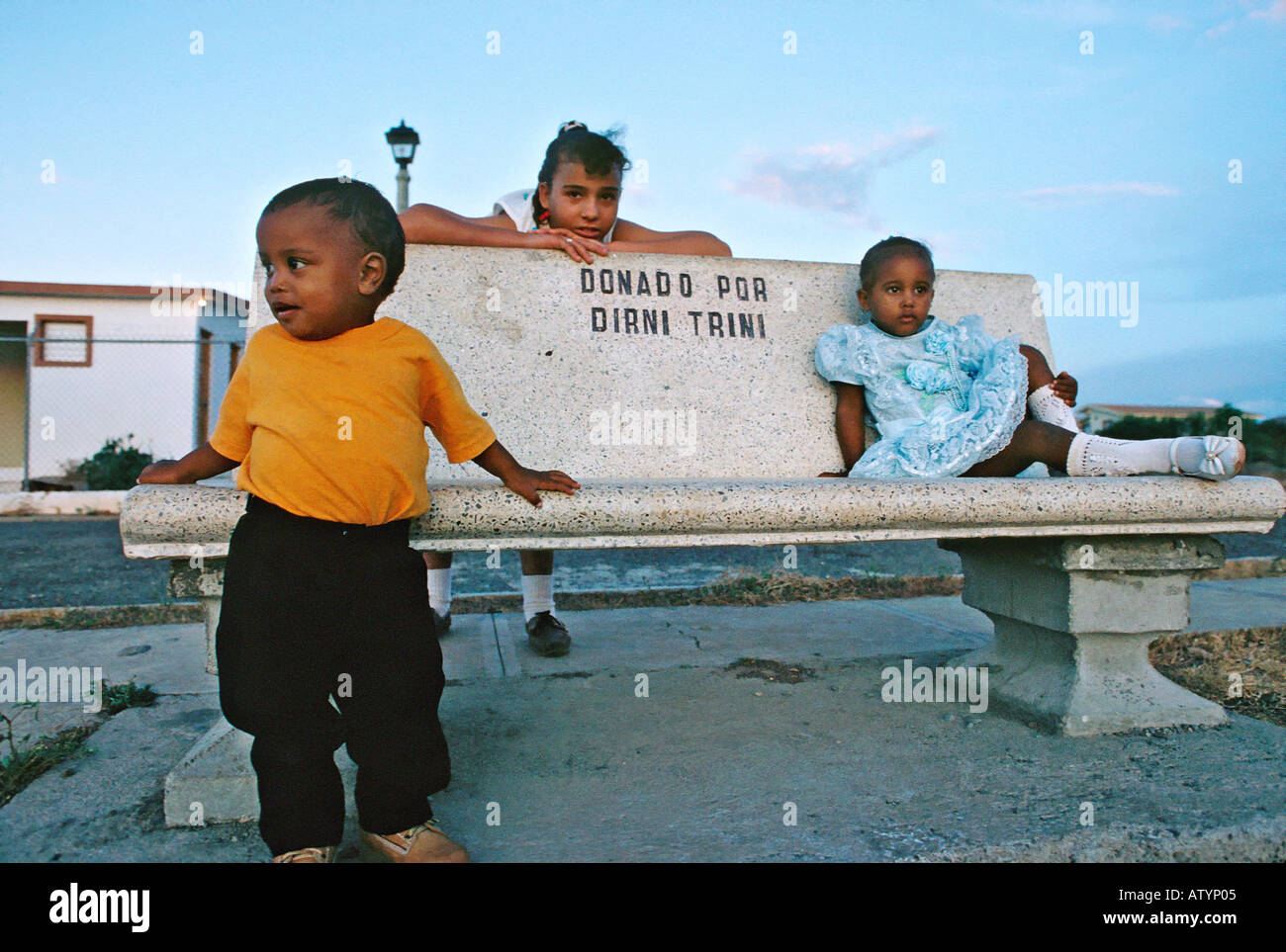 Three Dominican children on a park bench in El Castillo Dominican ...
