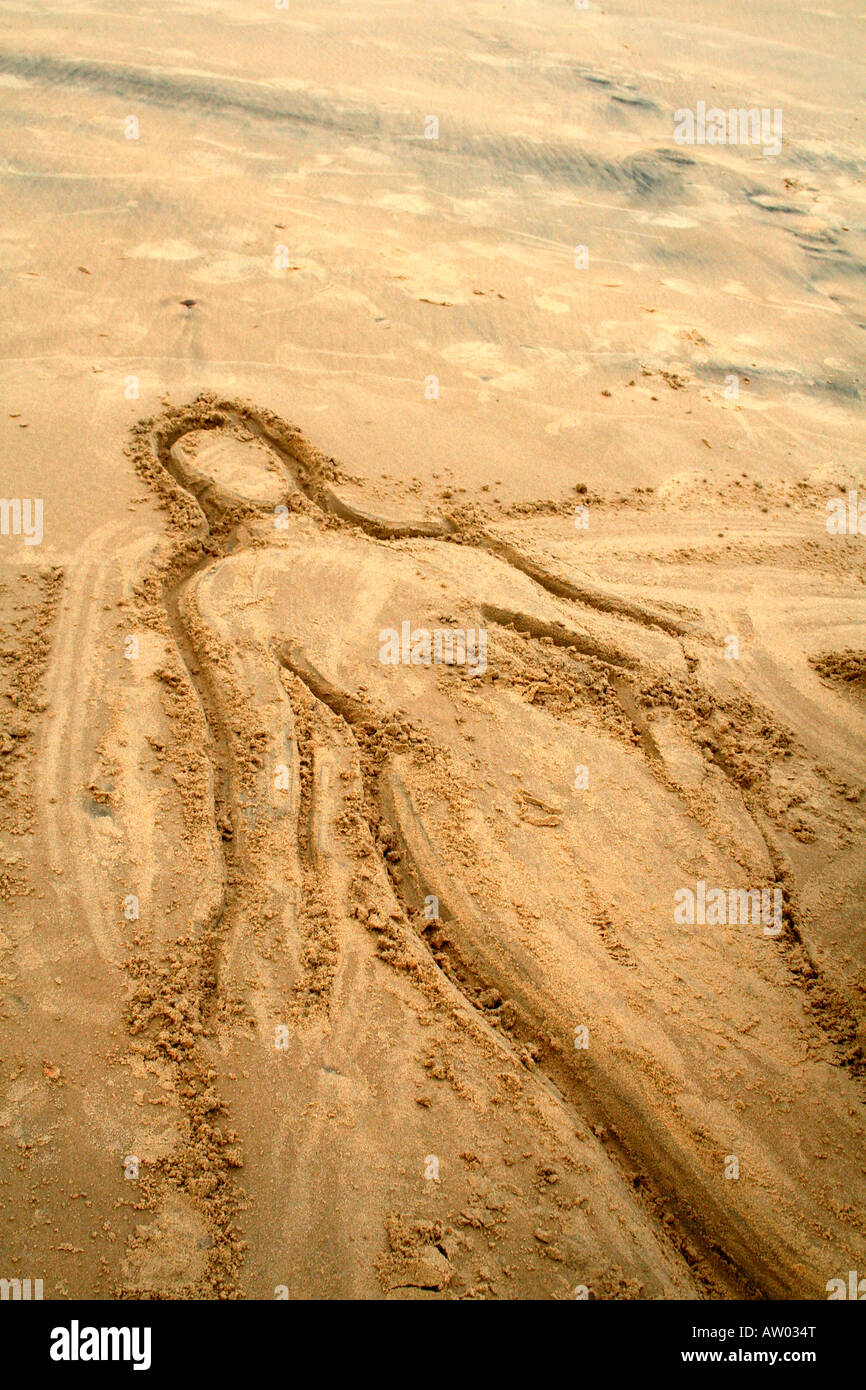 Beach sand art - shape of woman sketched on sand Stock Photo - Alamy
