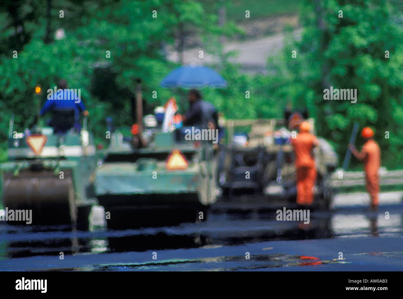 Road construction crew at work building a new road blurred by heat ...