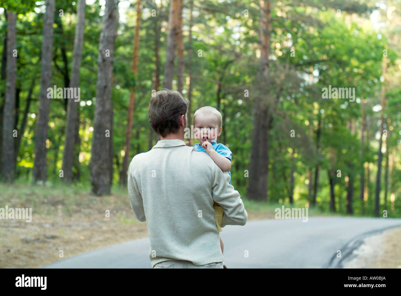 father walking with his baby through forest Stock Photo - Alamy