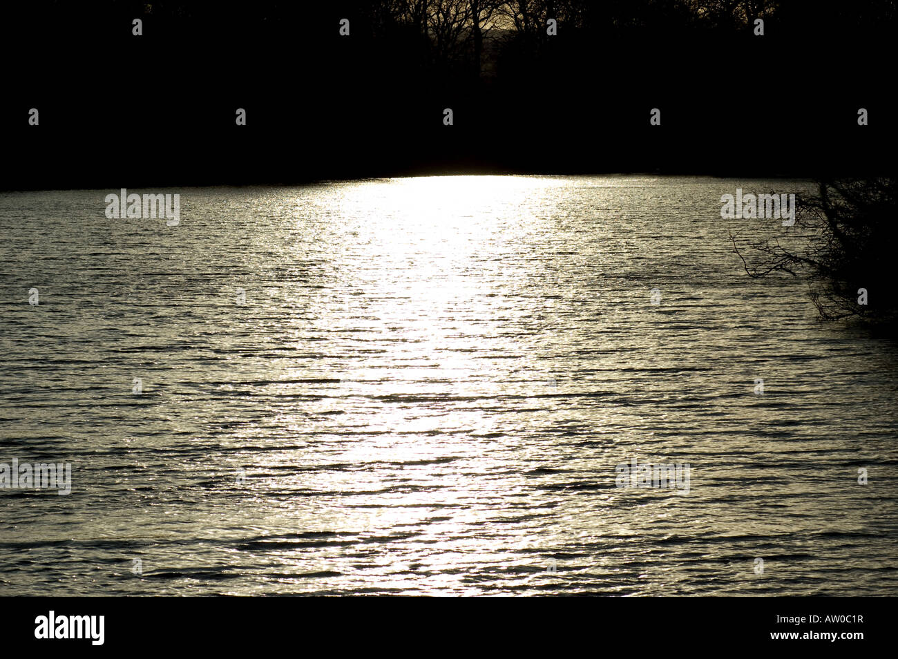 Sun setting over lake Stock Photo - Alamy