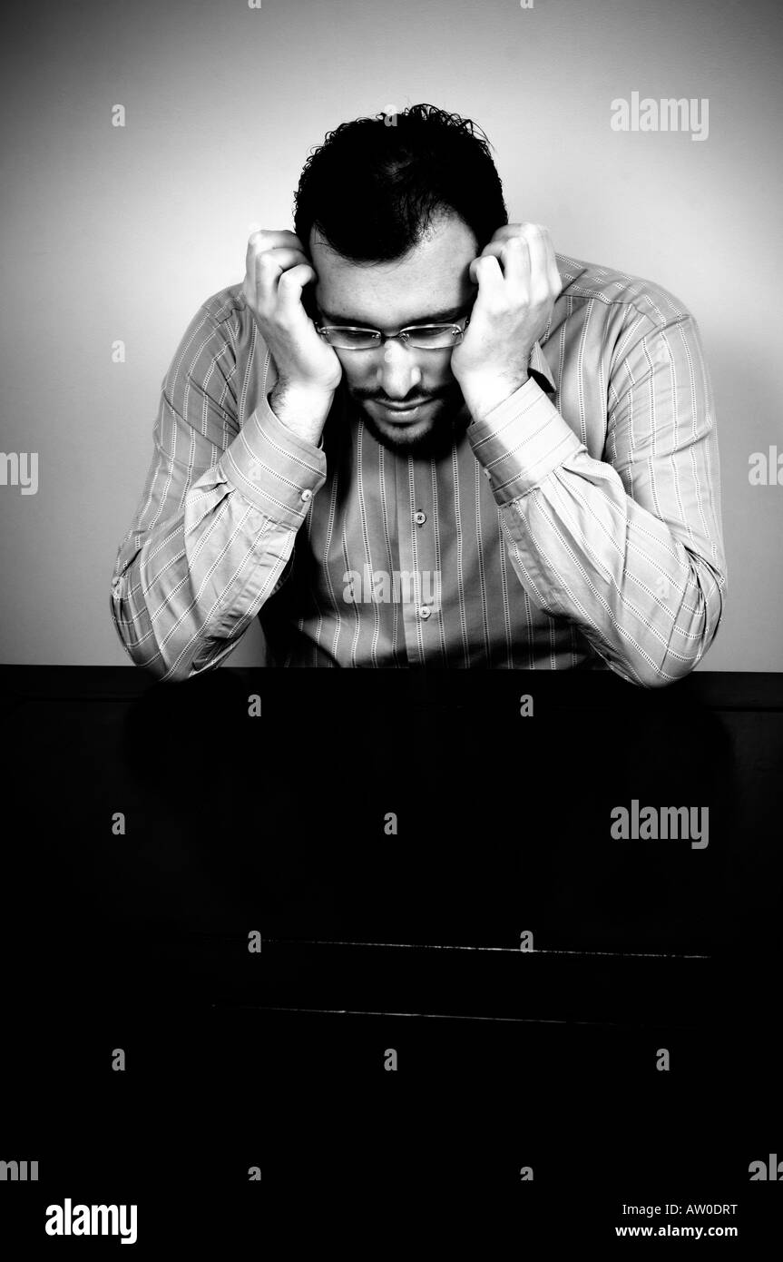 Depressed man head in hands sitting down to a table Stock Photo - Alamy