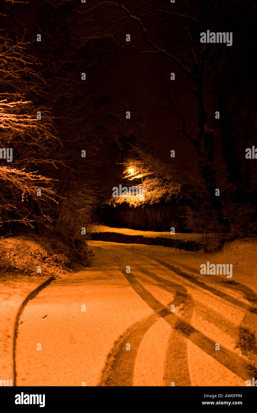Snow covered road illuminated with street light Stock Photo - Alamy
