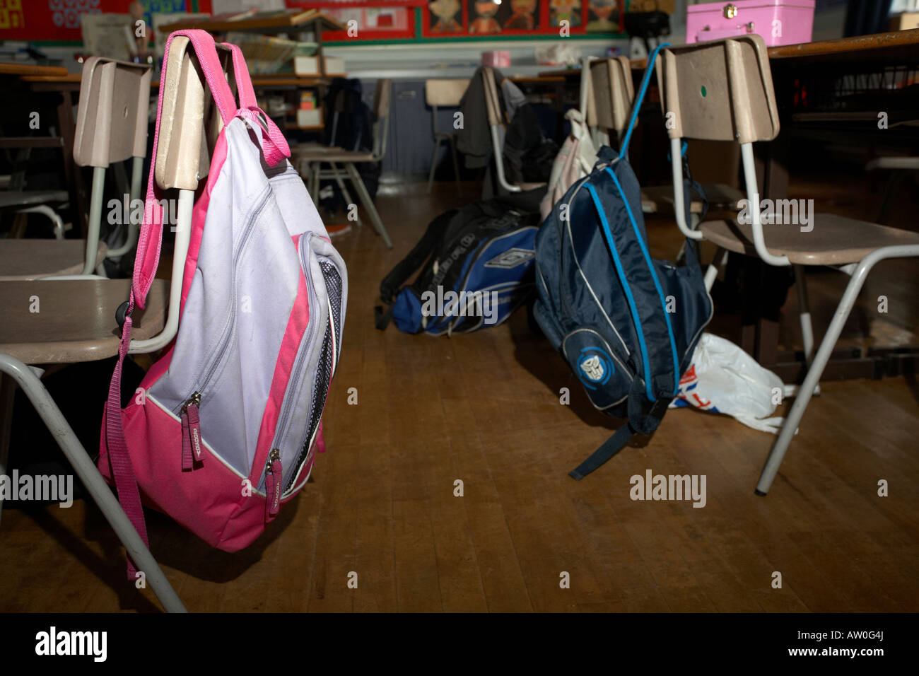 girls and boys schoolbag rucksacks hanging off the back of darkened ...