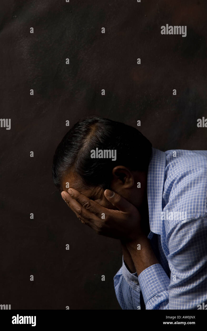 Indian man head in hands Stock Photo - Alamy