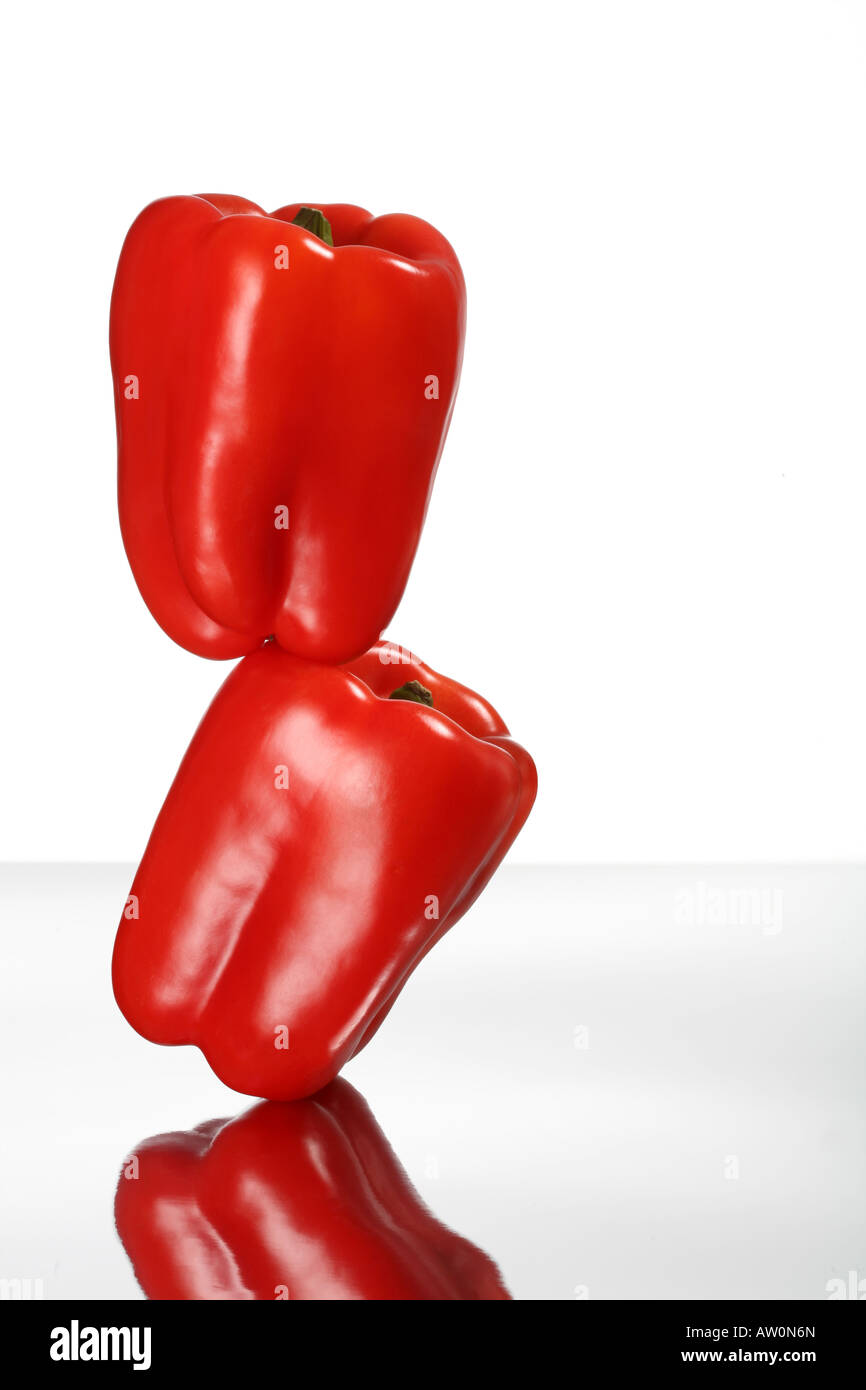 two red peppers balancing one a-top the other on a silver ground Stock ...