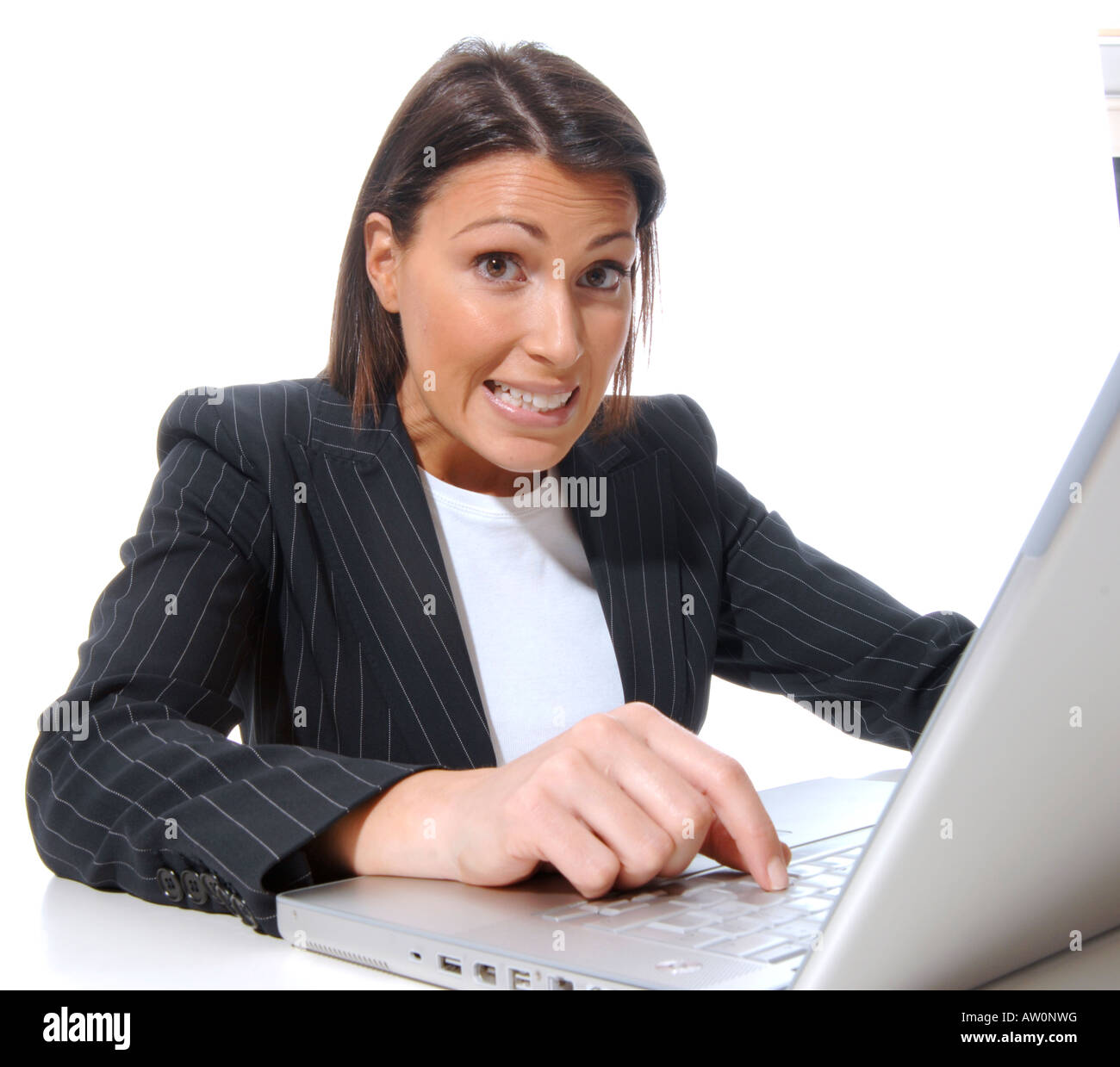 Woman pressing key on laptop looking apprehensive Stock Photo - Alamy