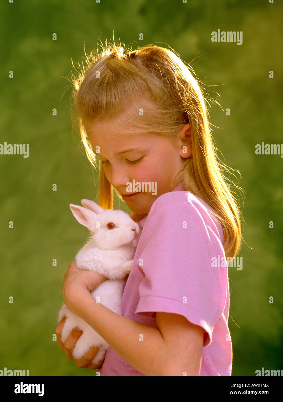 Blond girl with a little rabbit Stock Photo - Alamy