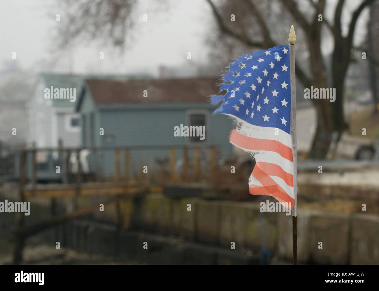 A worn and tattered American Flag waves defiantly in the breeze on a ...