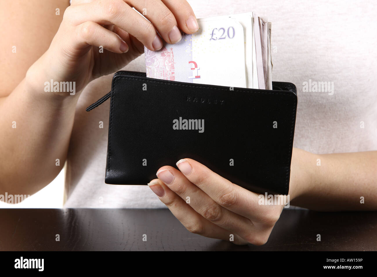 Young Woman Putting Money in Purse Model Released Stock Photo - Alamy