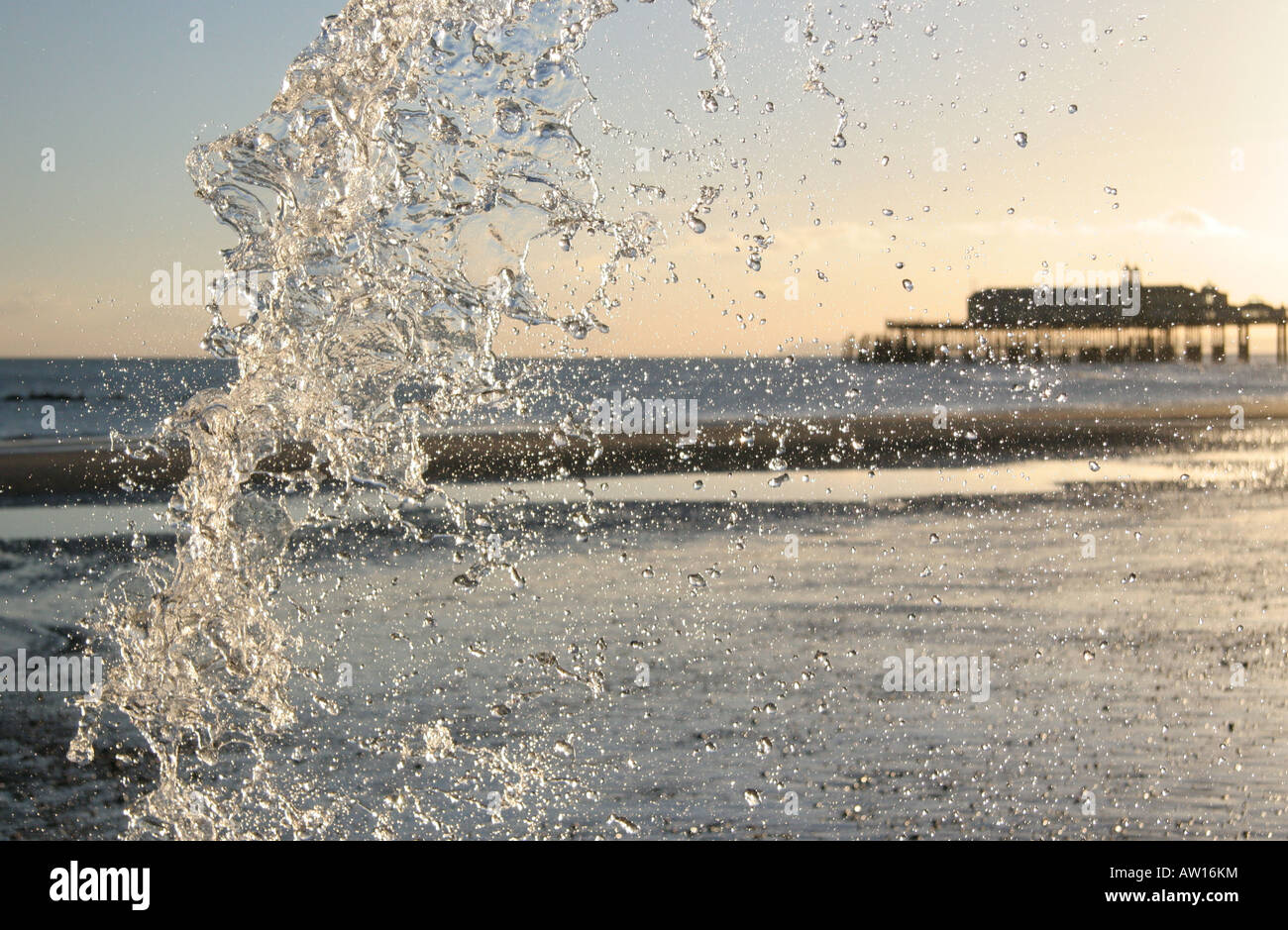 Water falling with Hastings pier in background at sunset Stock Photo ...