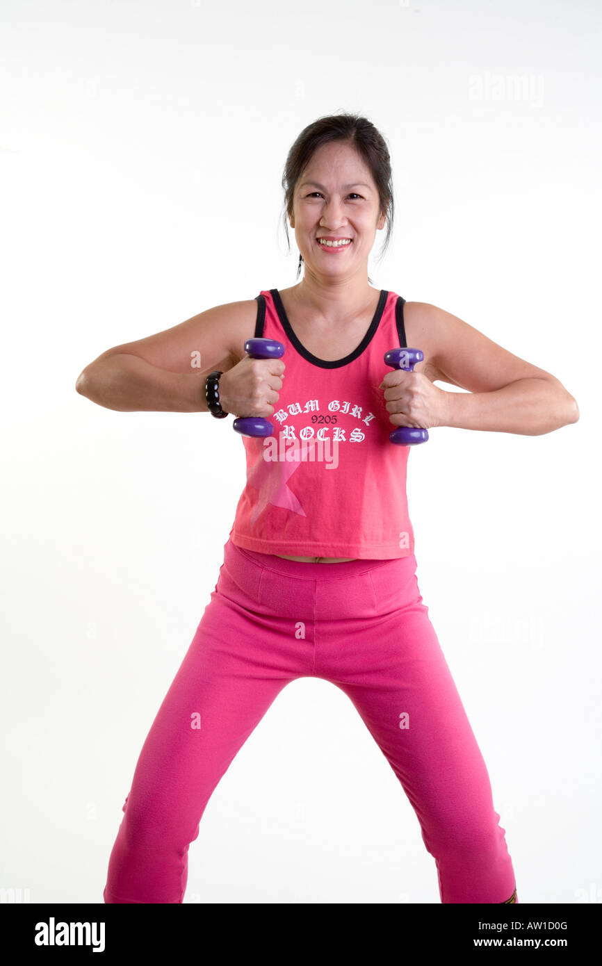 A woman in pink attire doing exercise routine using dumbbels Stock ...