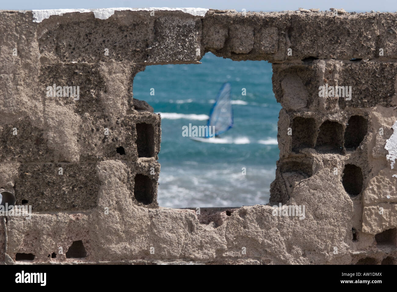 Windsurfer through a hole in a wall in Tenerife. Photo by Nikki Attree ...