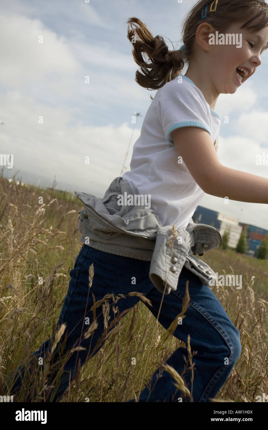Young girl running through high grass Stock Photo - Alamy