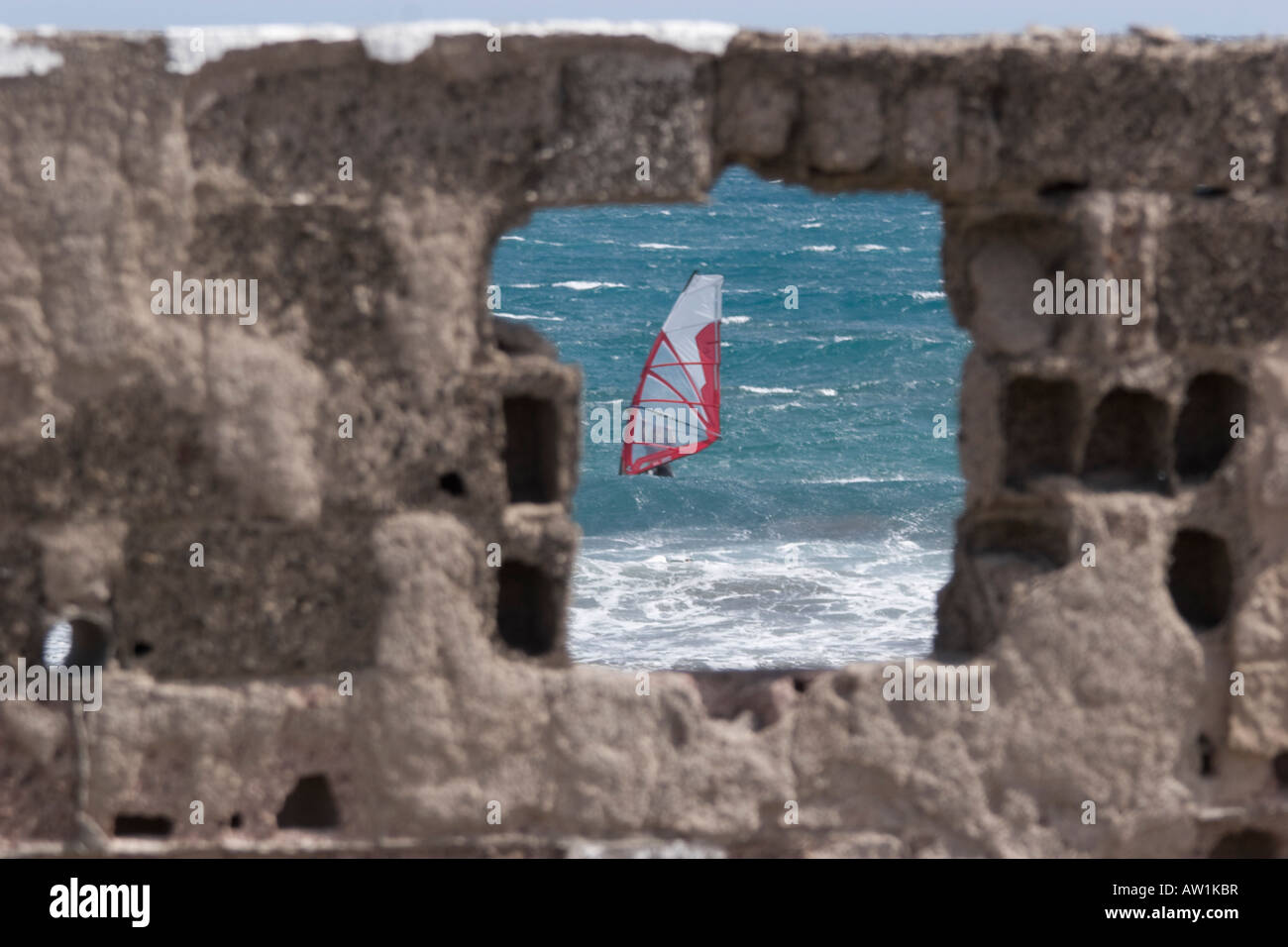 view of a windsurfer through a hole in a textured wall tenerife Stock ...