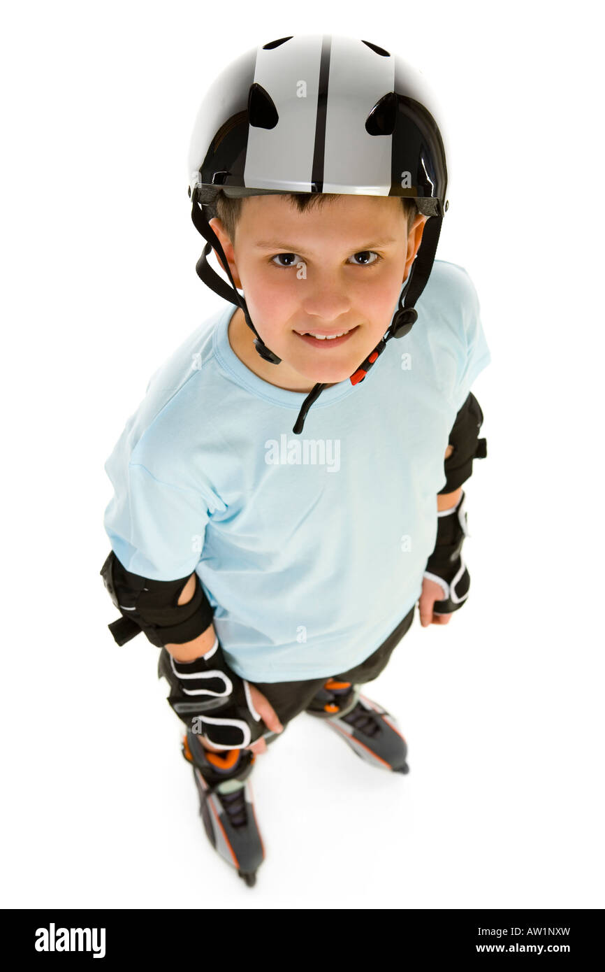 Young happy roller boy in protection kit standing and looking at camera ...