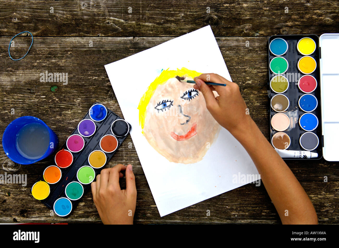 Child paints a face with water colours Stock Photo - Alamy