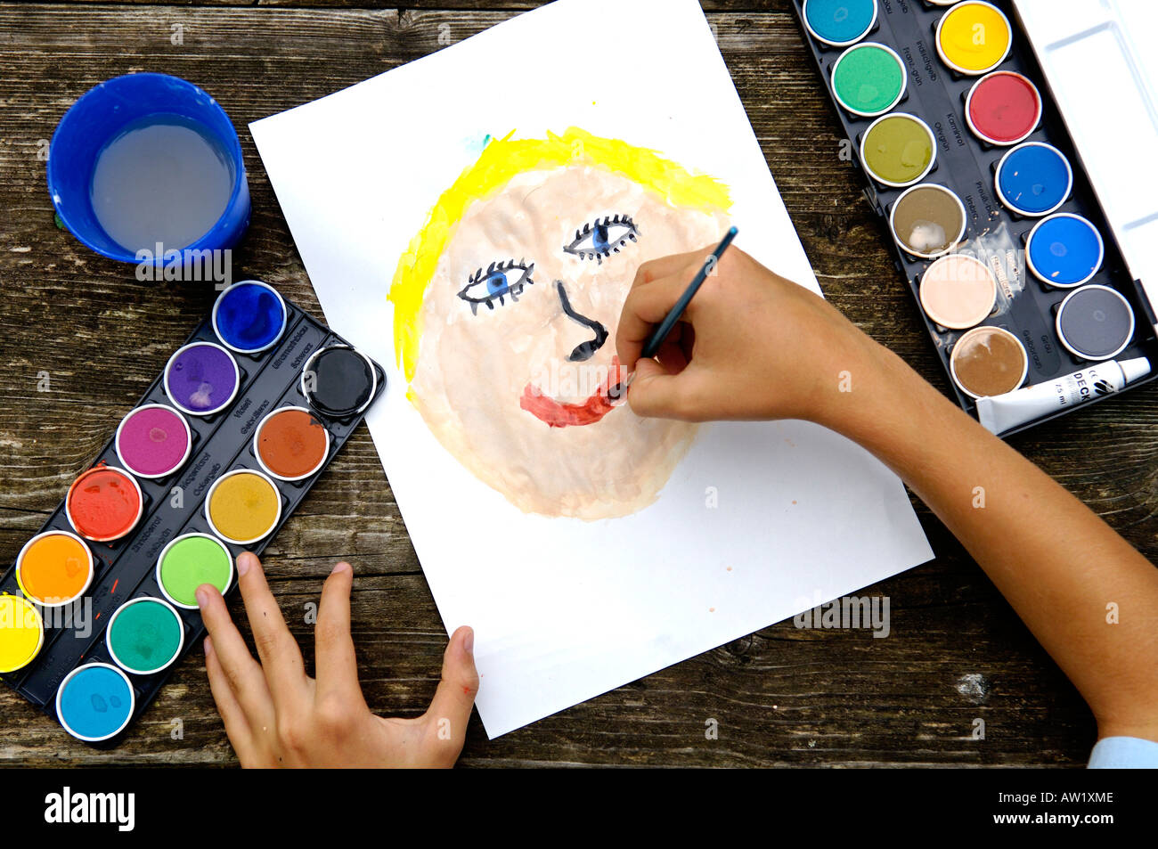 Child paints a face with water colours Stock Photo - Alamy