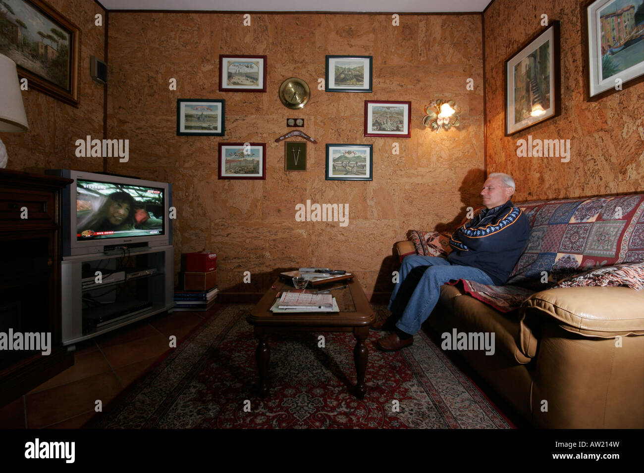 Man watching TV at home in the living room Stock Photo - Alamy